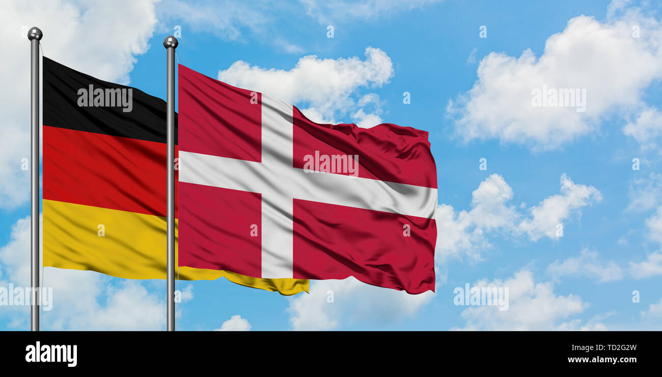Germany and Denmark flag waving in the wind against white cloudy blue ...