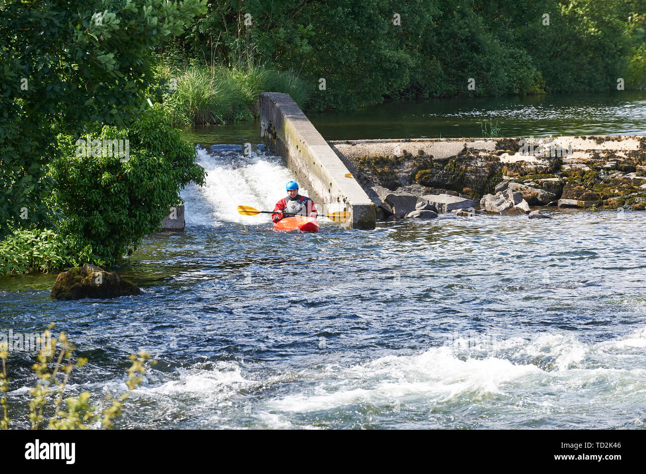 A man white water kayaking in the river Leven at Newby Bridge, South ...