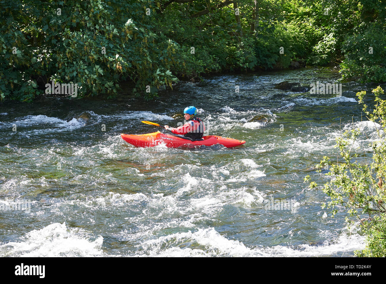 A man white water kayaking in the river Leven at Newby Bridge, South ...