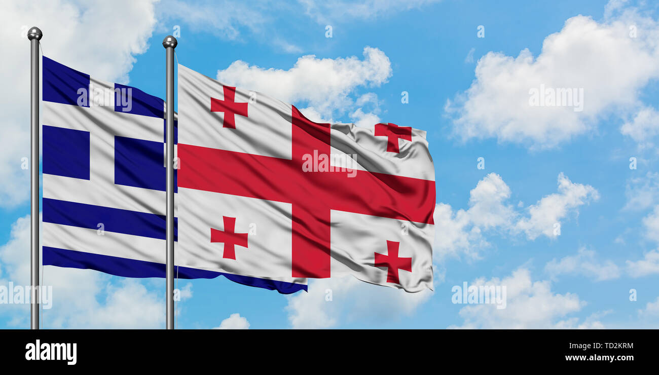 Greece and Georgia flag waving in the wind against white cloudy blue ...