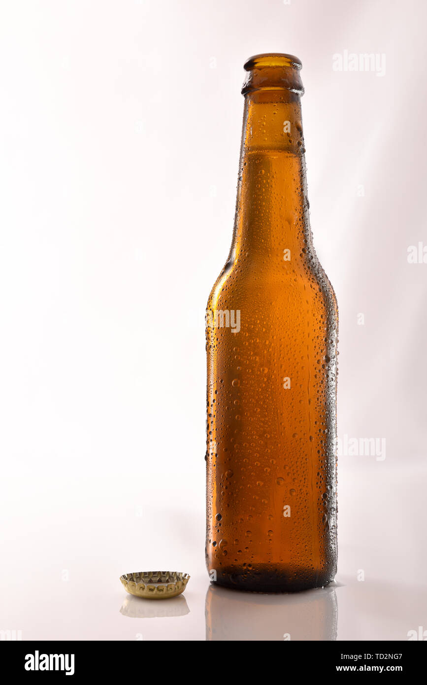 Beer bottle filled and open on glass table and black background ...