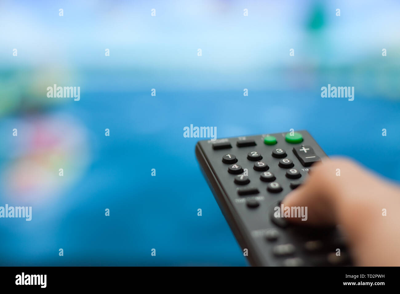 A hand changing the TV channel Stock Photo - Alamy