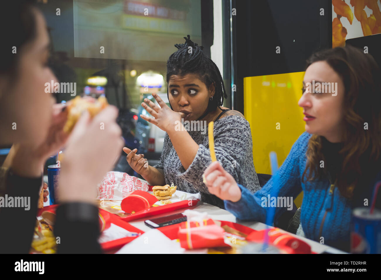 multiracial girlfriends eating together in fast food– break time ...