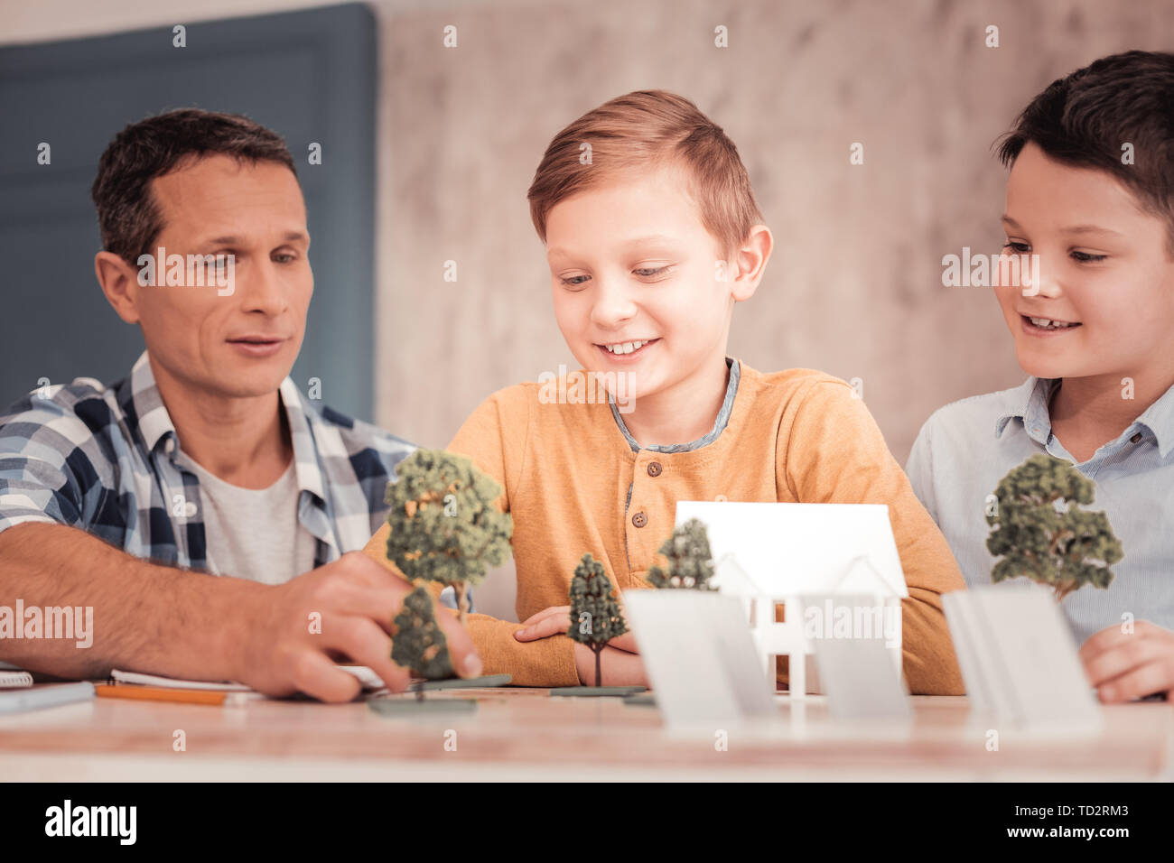 Blonde-haired cute boy speaking with his foster father and brother ...