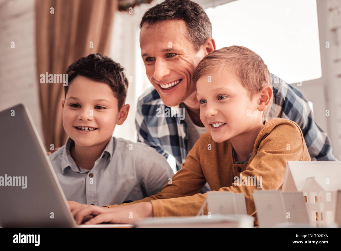 Smiling father feeling happy showing his children educational cartoon ...