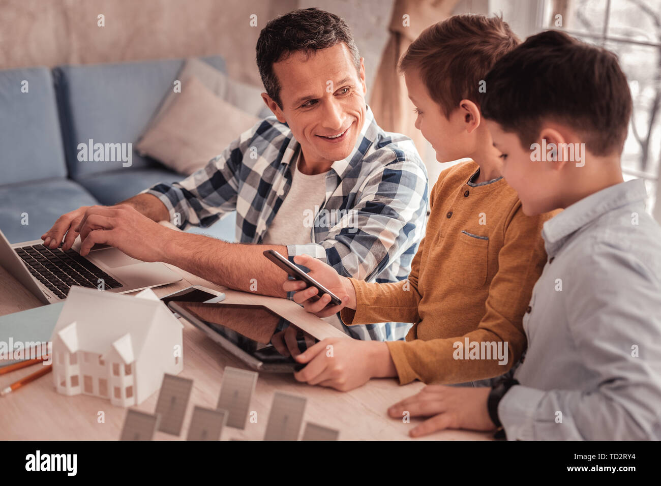 Smart devoted father telling his sons about renewable energy Stock ...