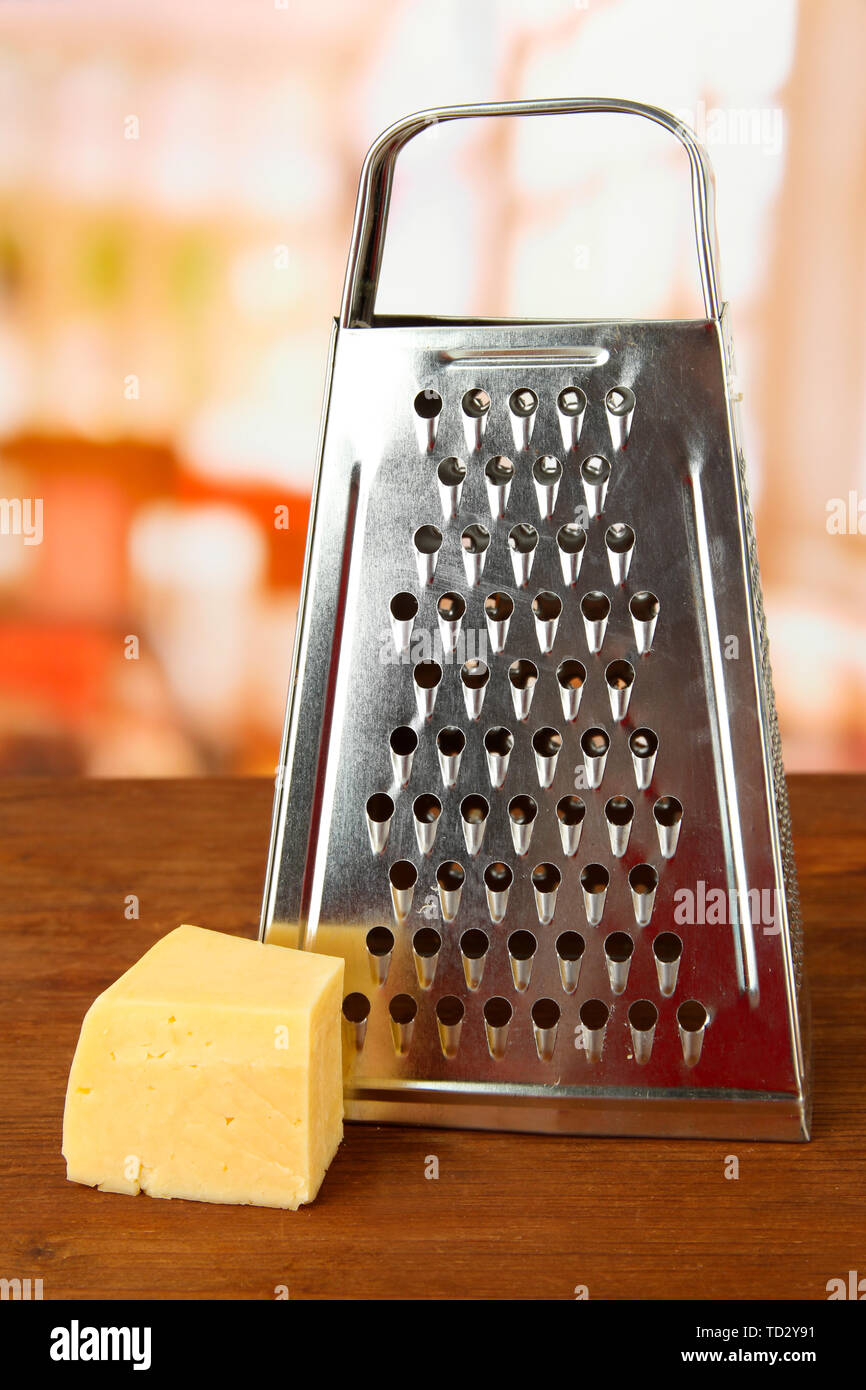 Metal grater and cheese, on bright background Stock Photo - Alamy