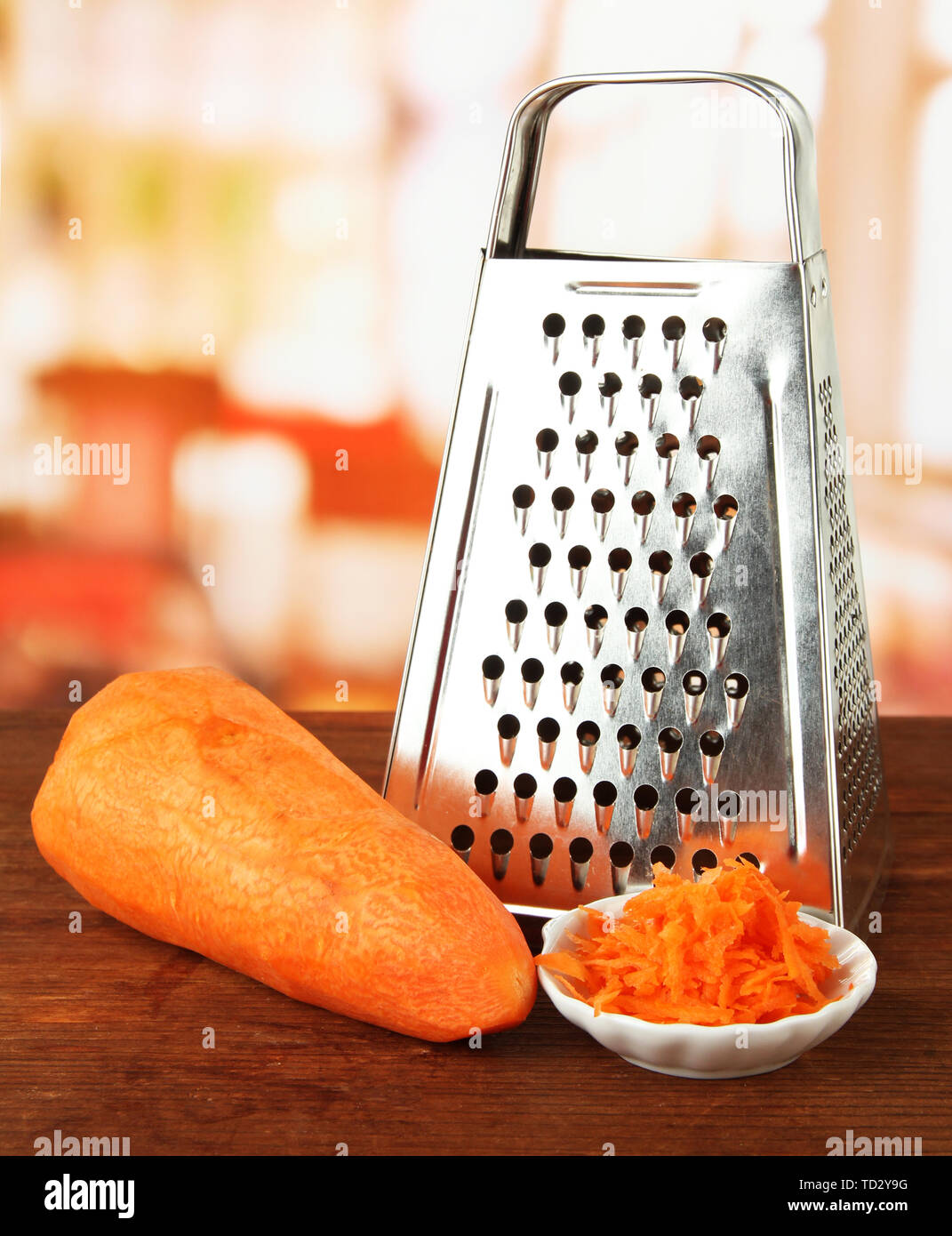 Metal grater and carrot, on bright background Stock Photo - Alamy