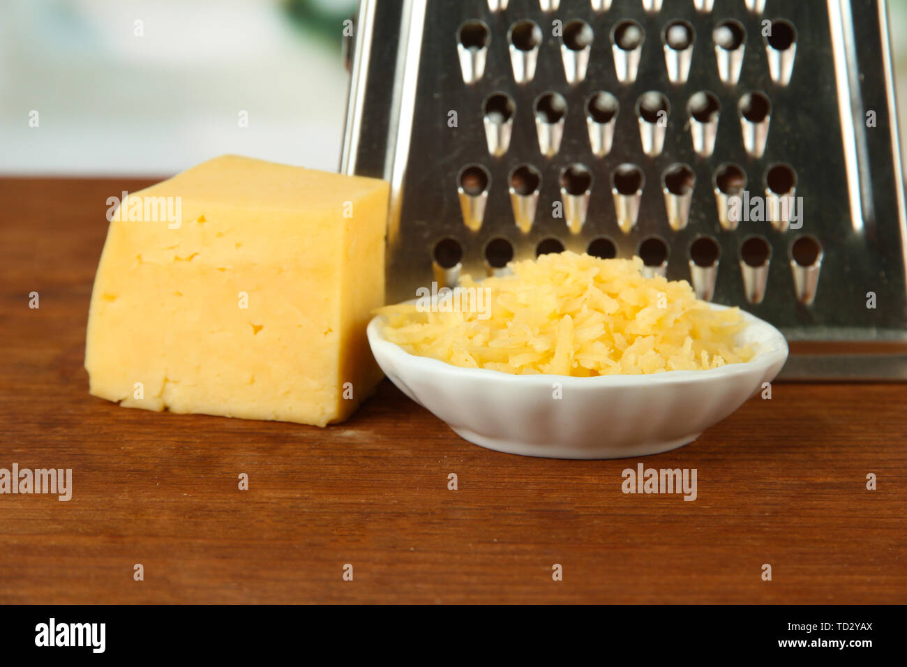 Metal grater and cheese, on bright background Stock Photo - Alamy