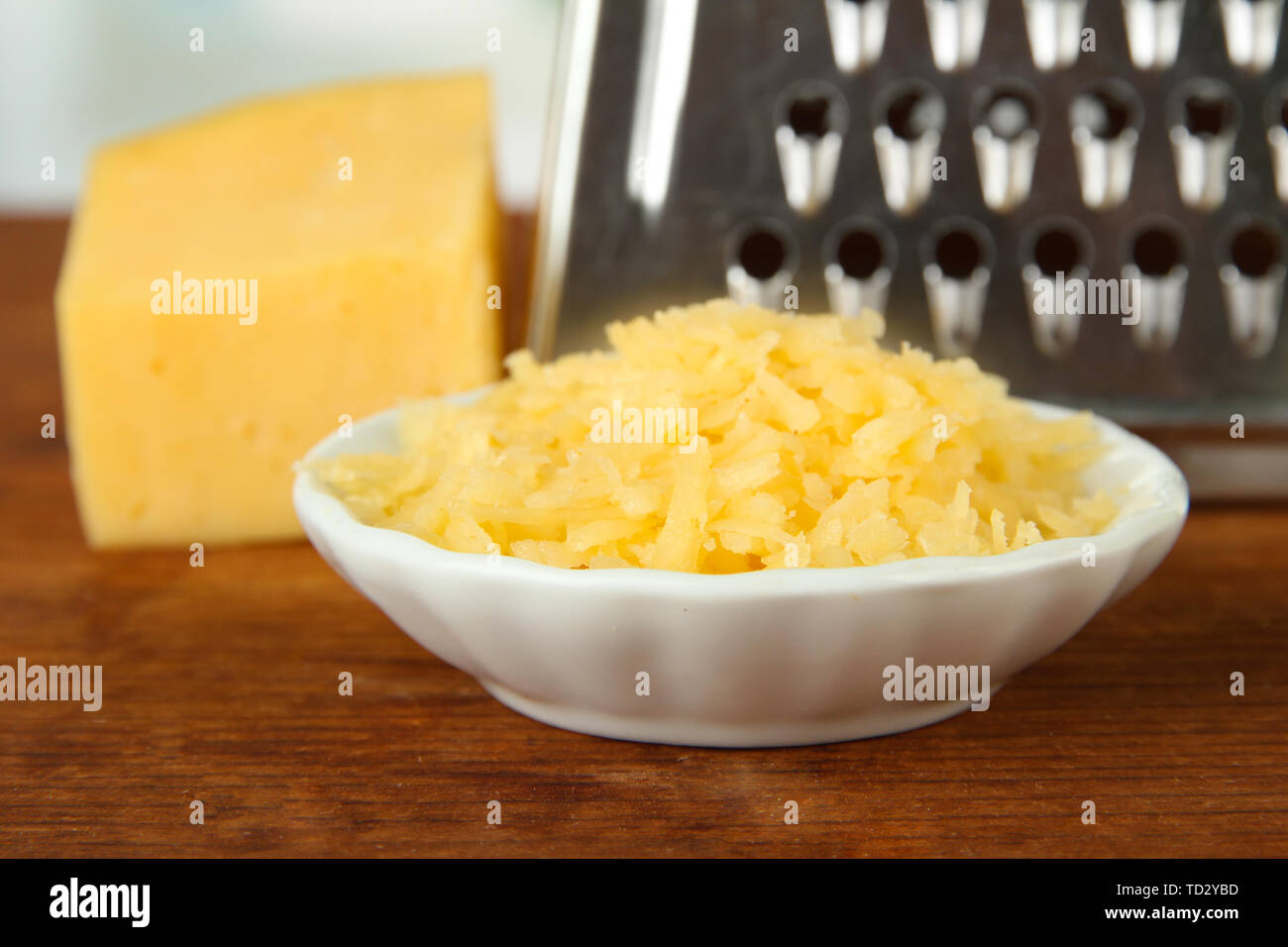 Metal grater and cheese, on bright background Stock Photo - Alamy