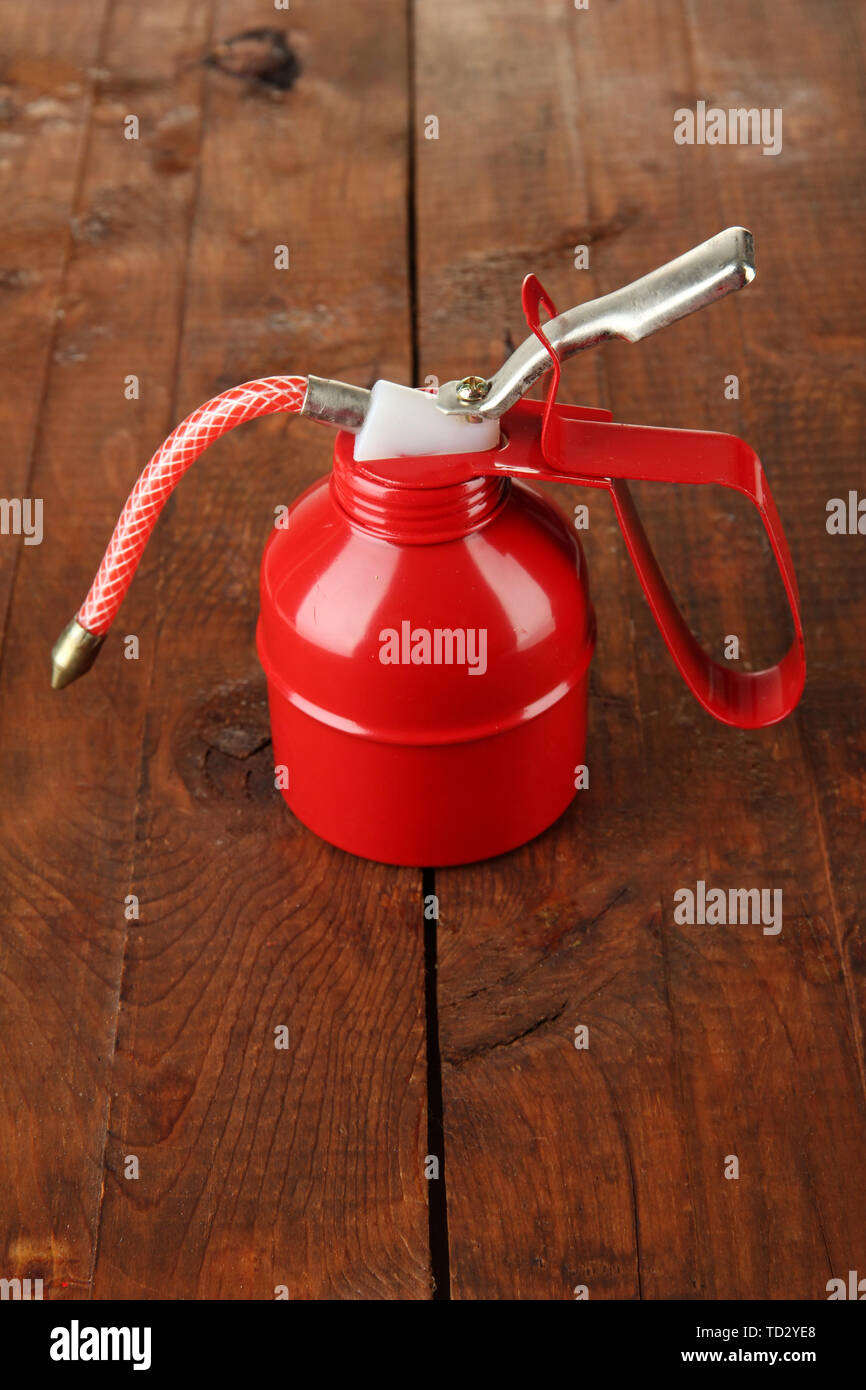 Red oil can, on wooden background Stock Photo - Alamy