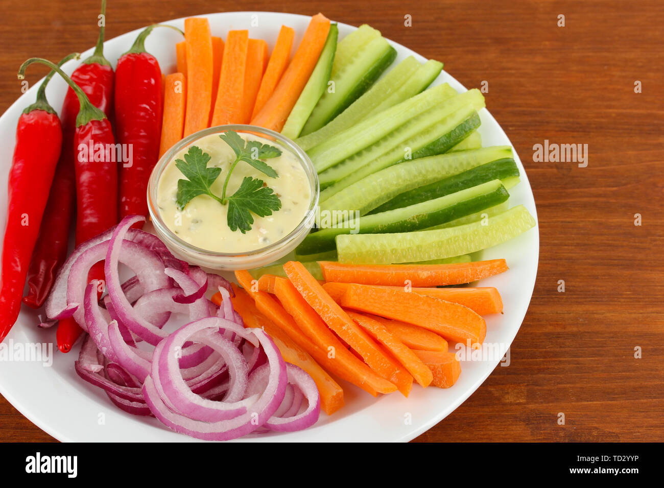 Assorted raw vegetables sticks in plate on wooden table close up Stock ...