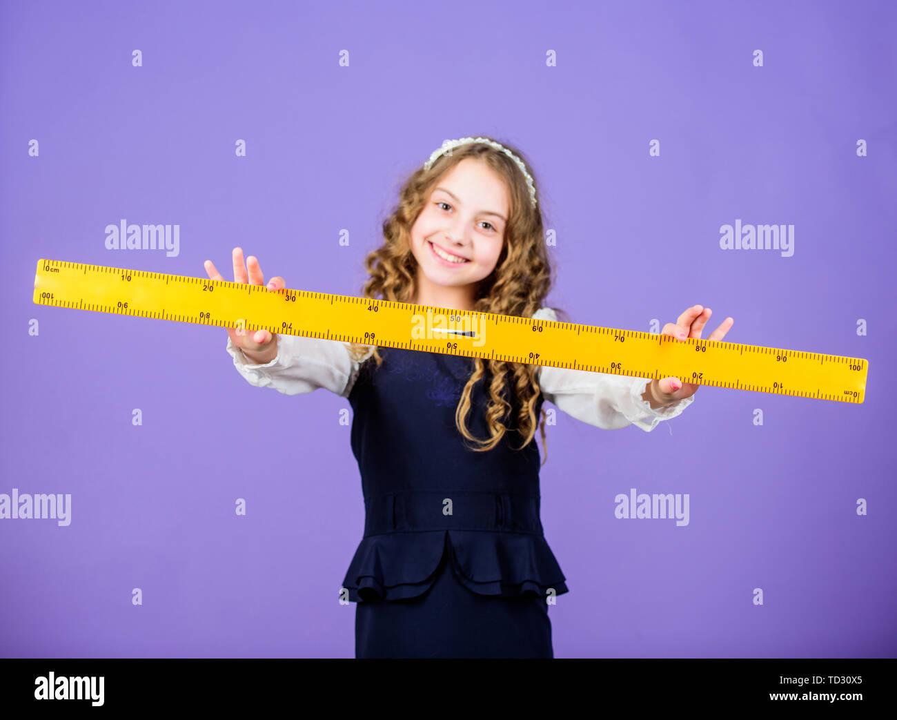 Kid school uniform hold ruler. Pupil cute girl with big ruler. Geometry ...