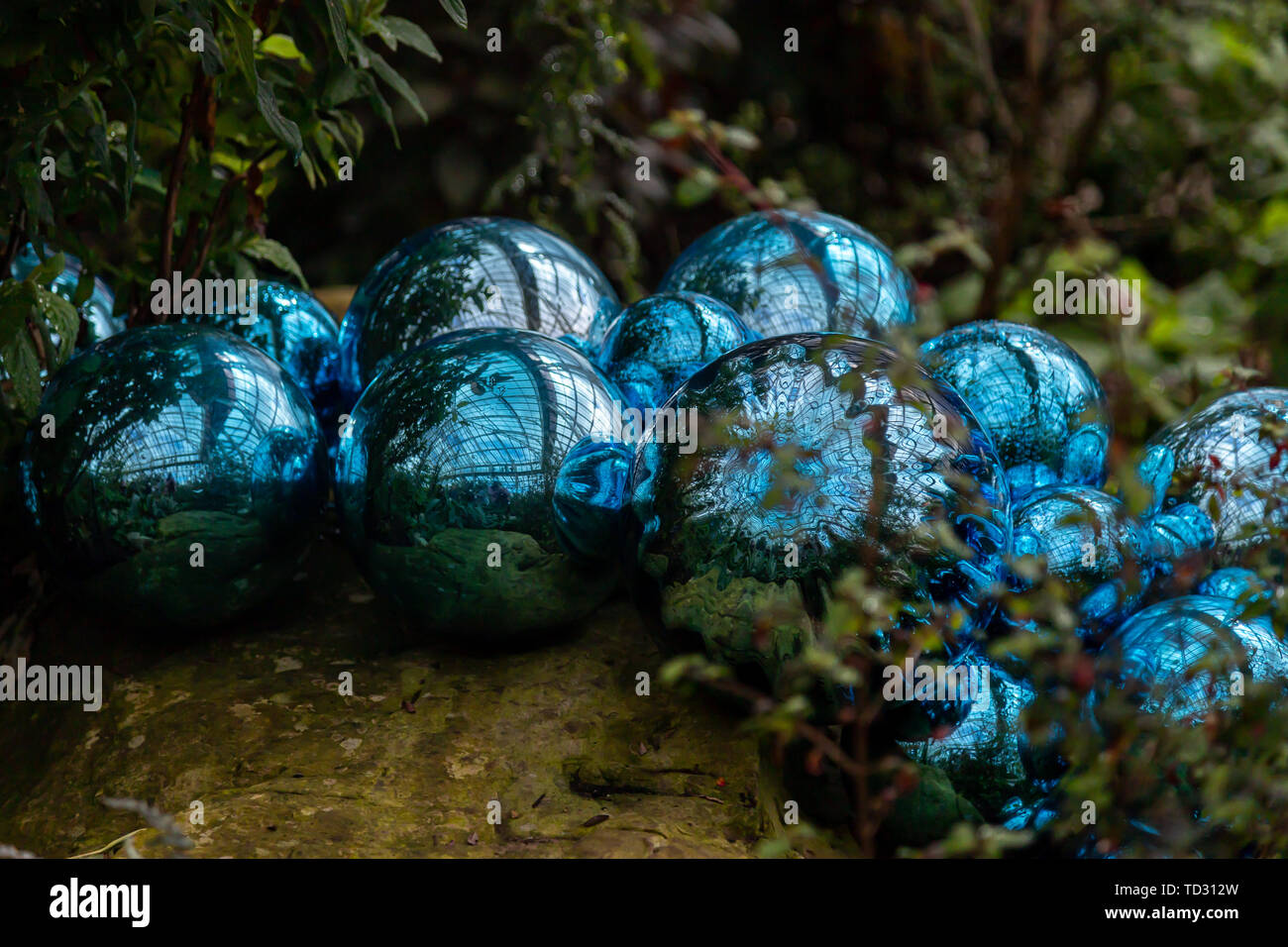 A group of blue reflective balls are part of the glass sculptures by ...