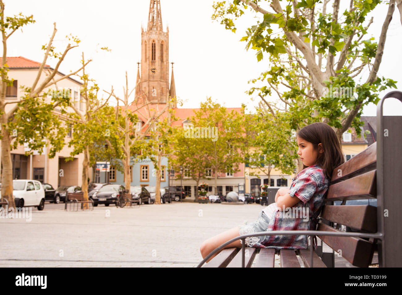 Girl sitting on a banch in the Square of European town Stock Photo - Alamy