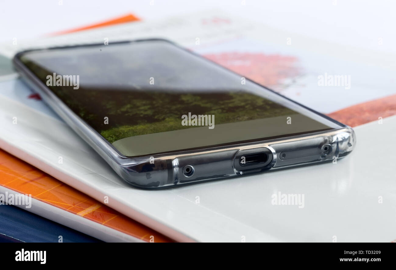 On the stack of magazines is a modern smartphone. Presented close-up ...
