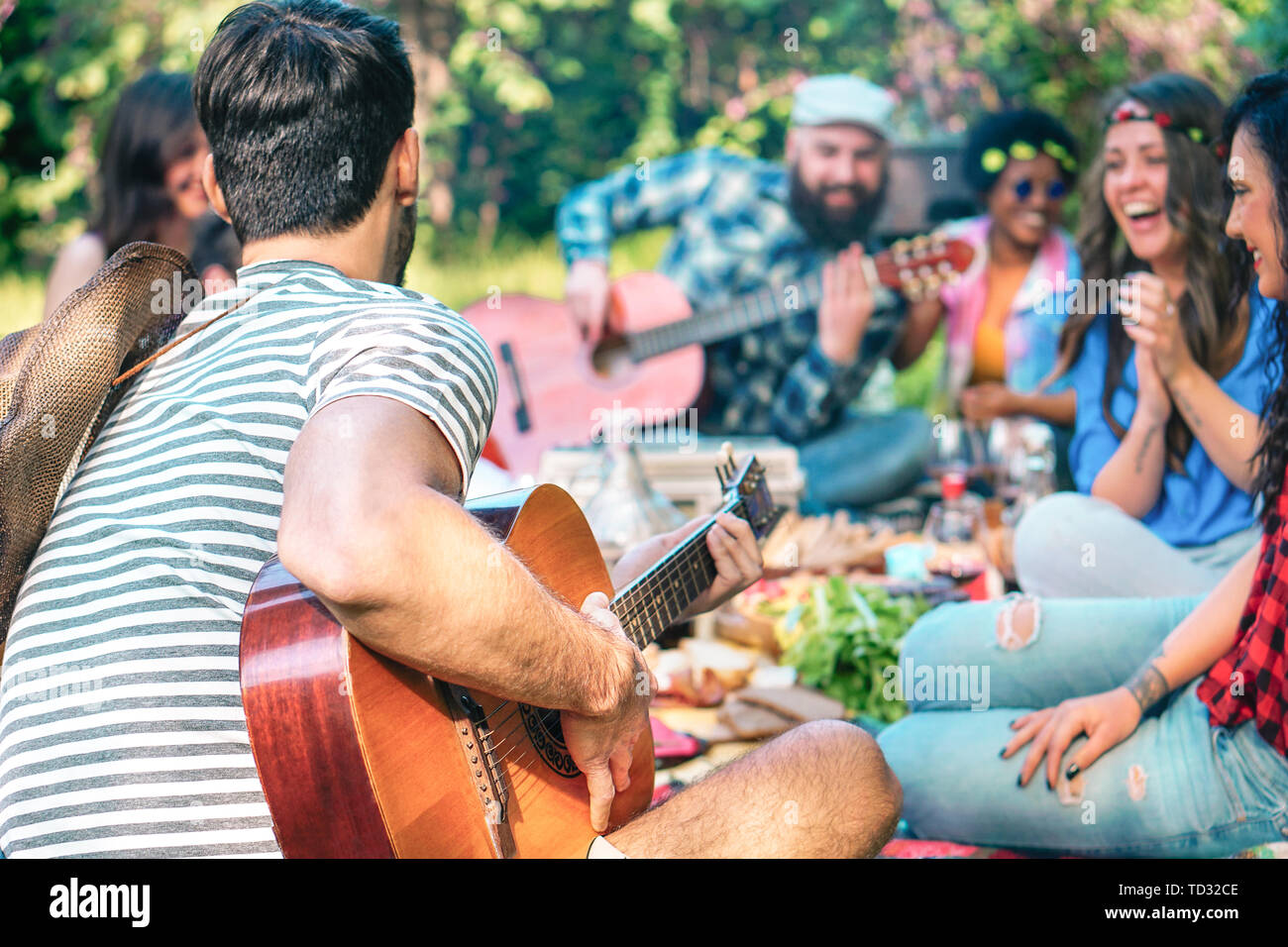 Young people doing picnic and playing guitar in park - Group of happy ...
