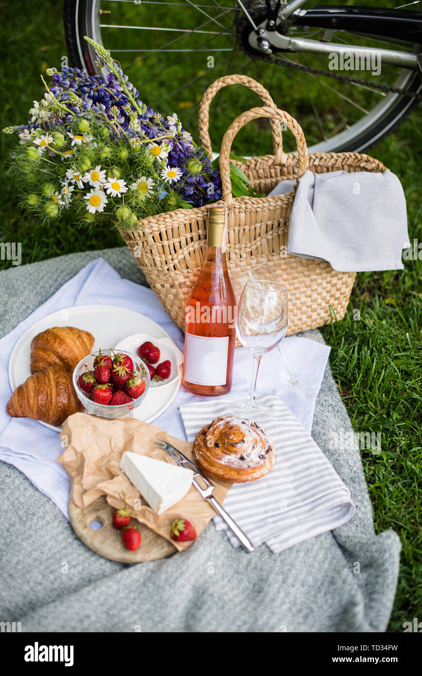 Beautiful summer picnic with strawberries, cheese and rose wine on the ...