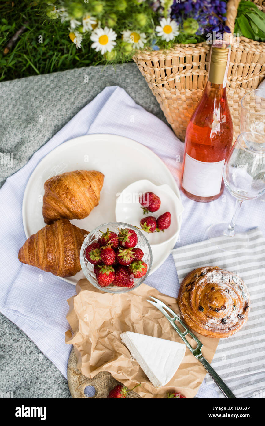Beautiful summer picnic with strawberries, cheese and rose wine on the ...