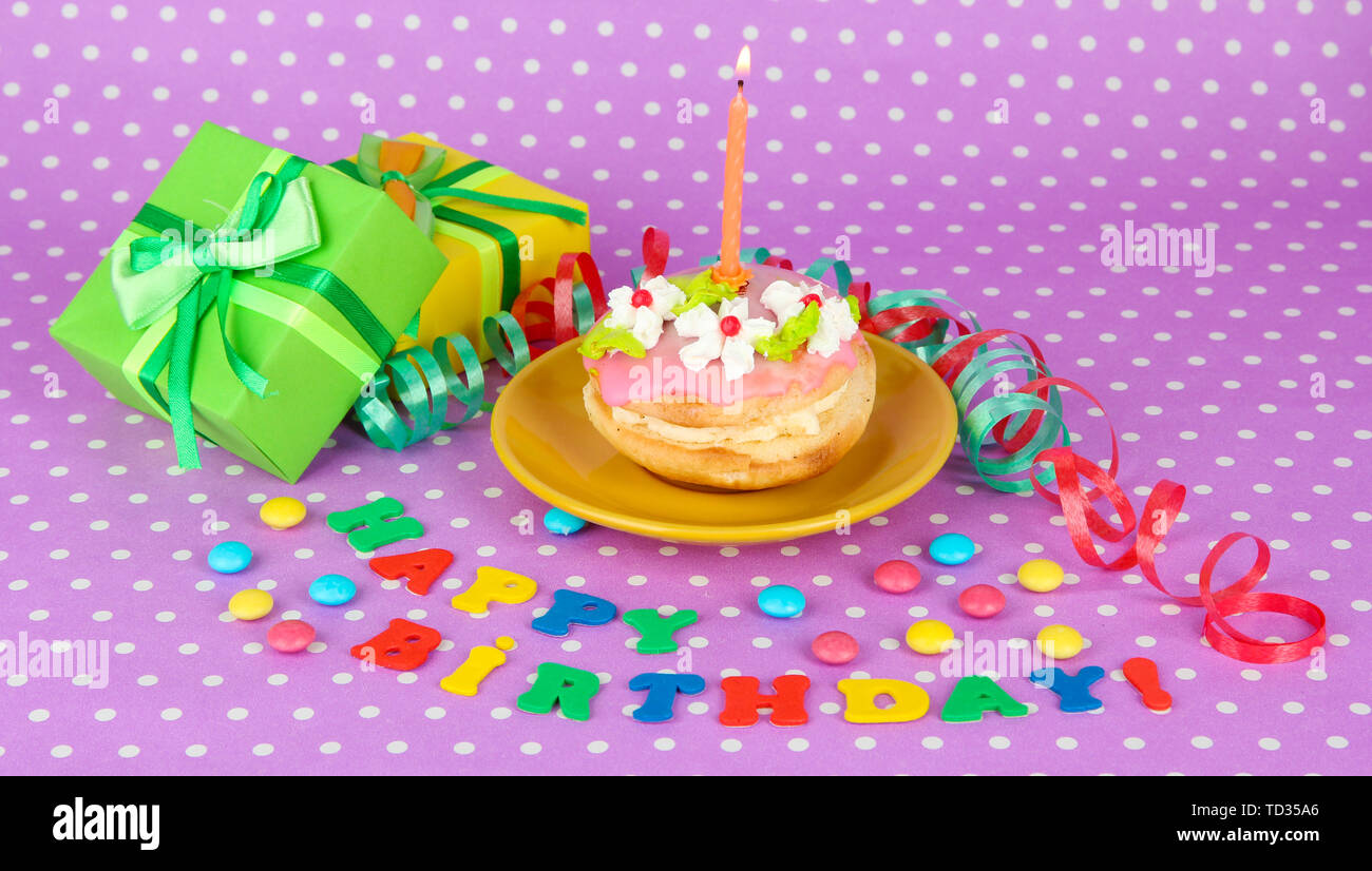 Colorful birthday cake with candle and gifts on pink background Stock ...