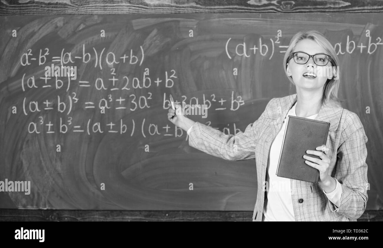 Teacher smart woman with book explain topic near chalkboard. School ...