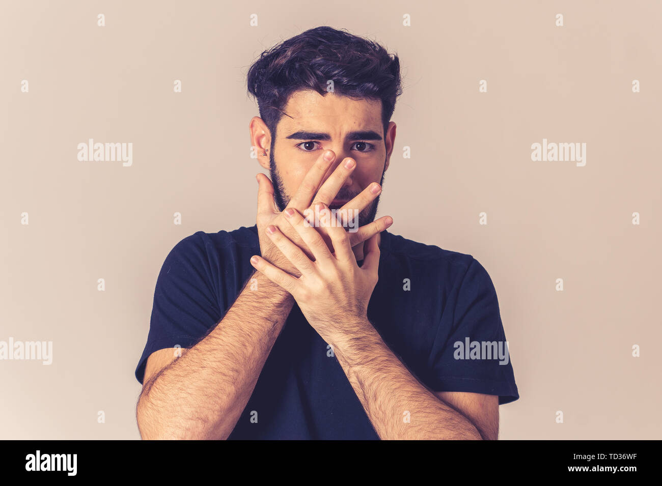 Young man feeling scared and shocked making fear anxiety gestures ...
