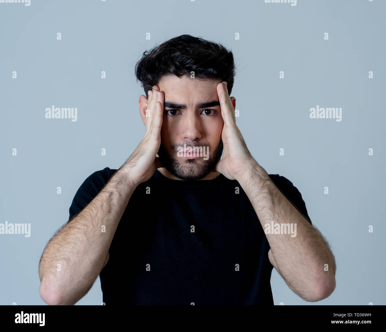 Young man feeling scared and shocked making fear anxiety gestures ...