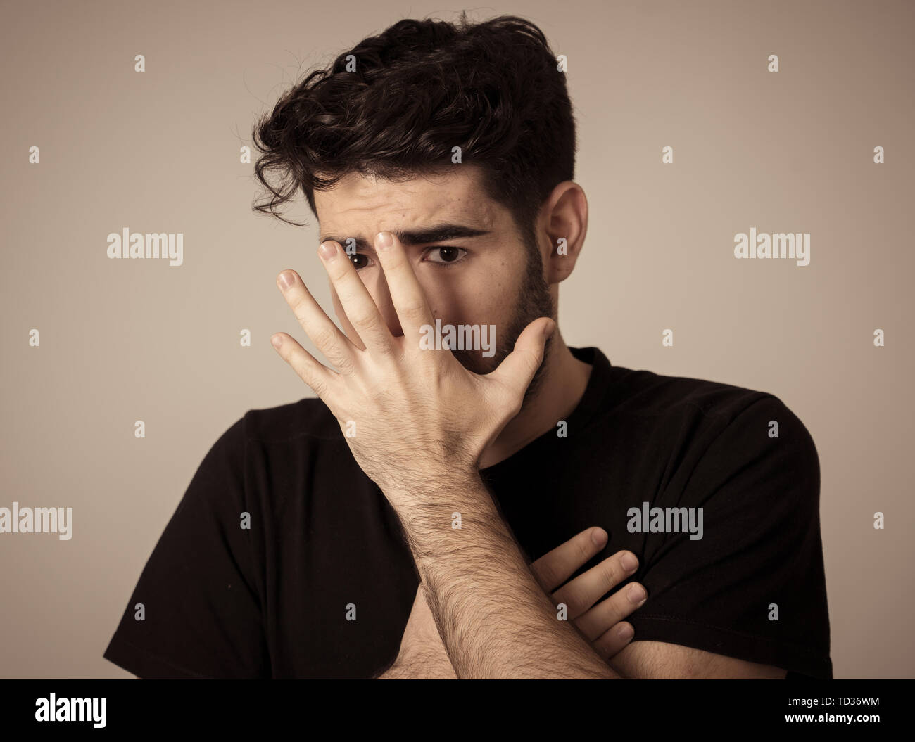 Young man feeling scared and shocked making fear anxiety gestures ...