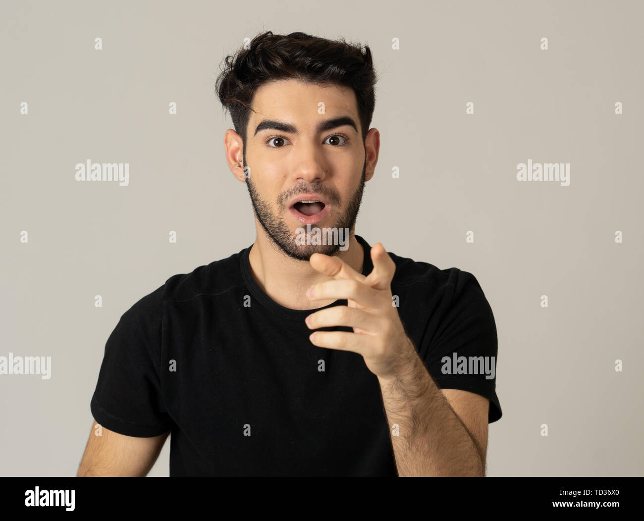 Portrait of a handsome latin young man surprised and shocked hearing ...