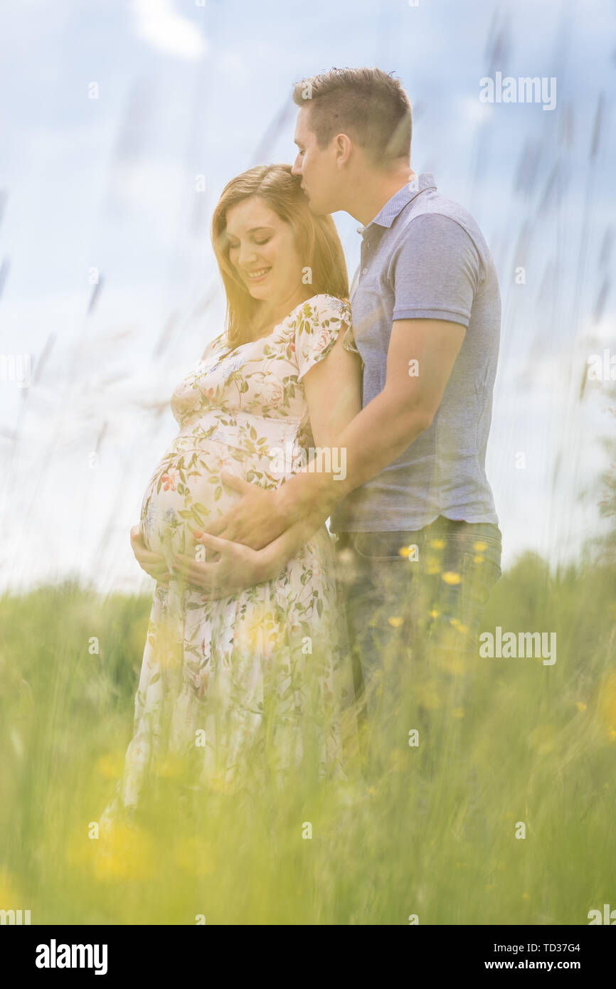 Young happy pregnant couple hugging in nature Stock Photo - Alamy