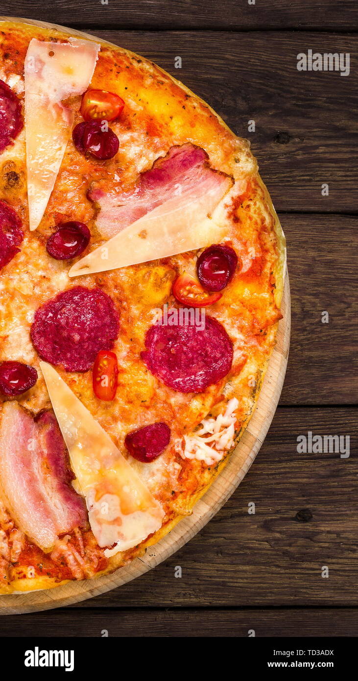 Delicious italian pizza with salami, bacon and parmesan Stock Photo - Alamy