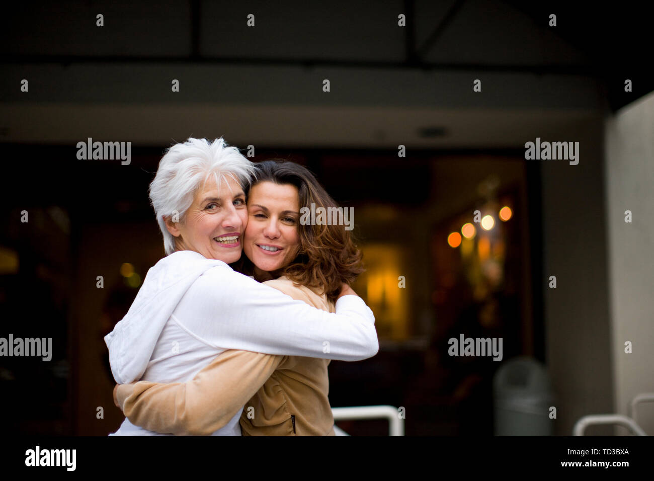 Portrait of two smiling women with arms around each other Stock Photo ...