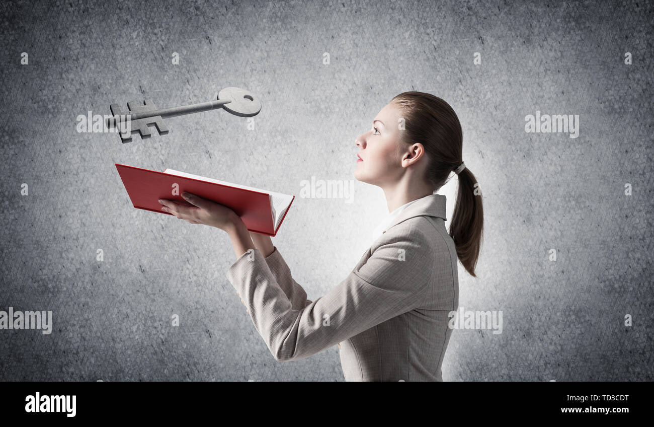 Woman showing big metal key Stock Photo - Alamy