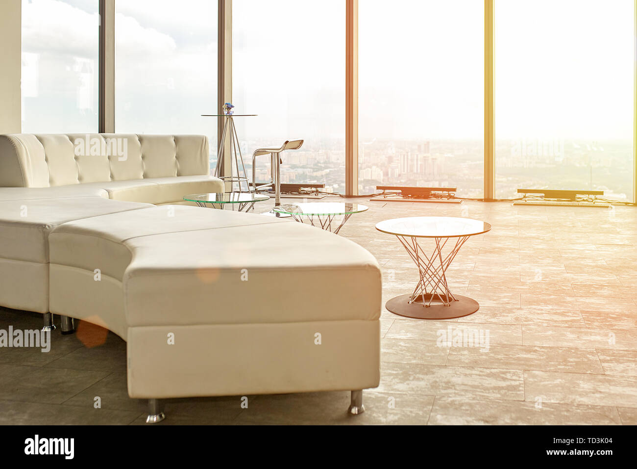High end design in a skyscraper, a sofa, tables with a view to the view ...