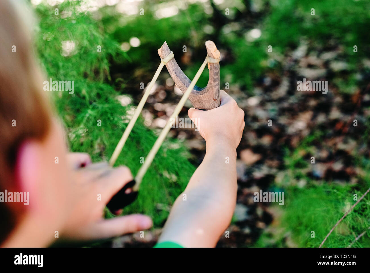 Child playing with his slingshot in a park having fun in freedom Stock ...