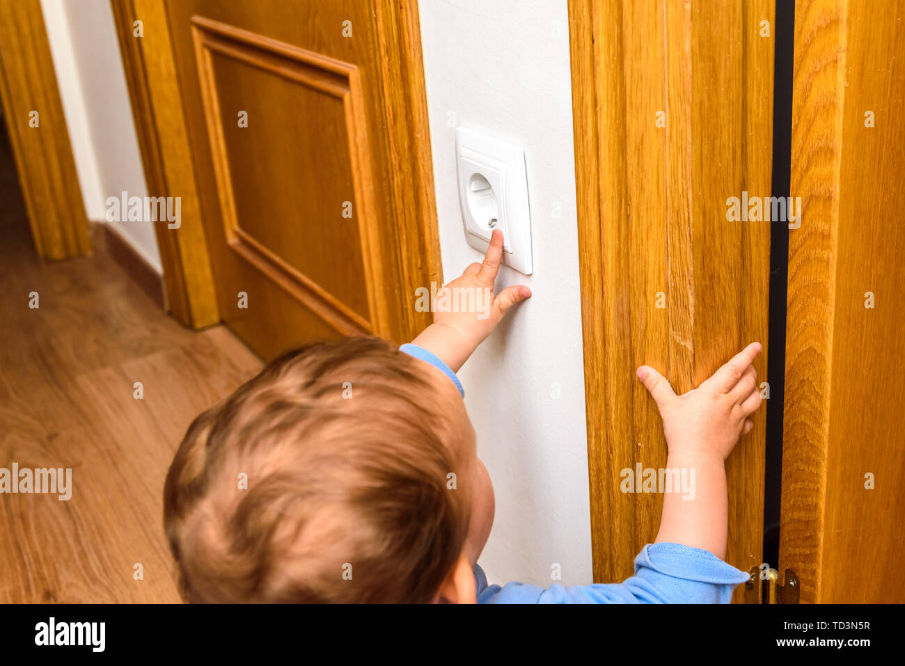 Baby introducing a finger in an electric socket, concept of childhood ...