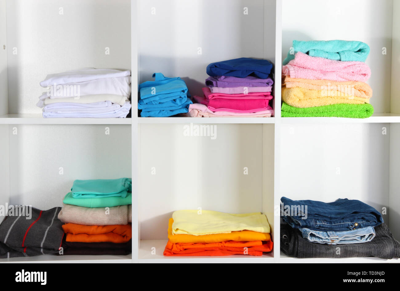 Clothes neatly folded on shelves Stock Photo - Alamy