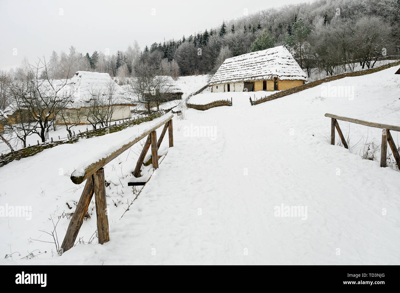 Authentic Eastern Europe village in winter with thatched roof huts ...