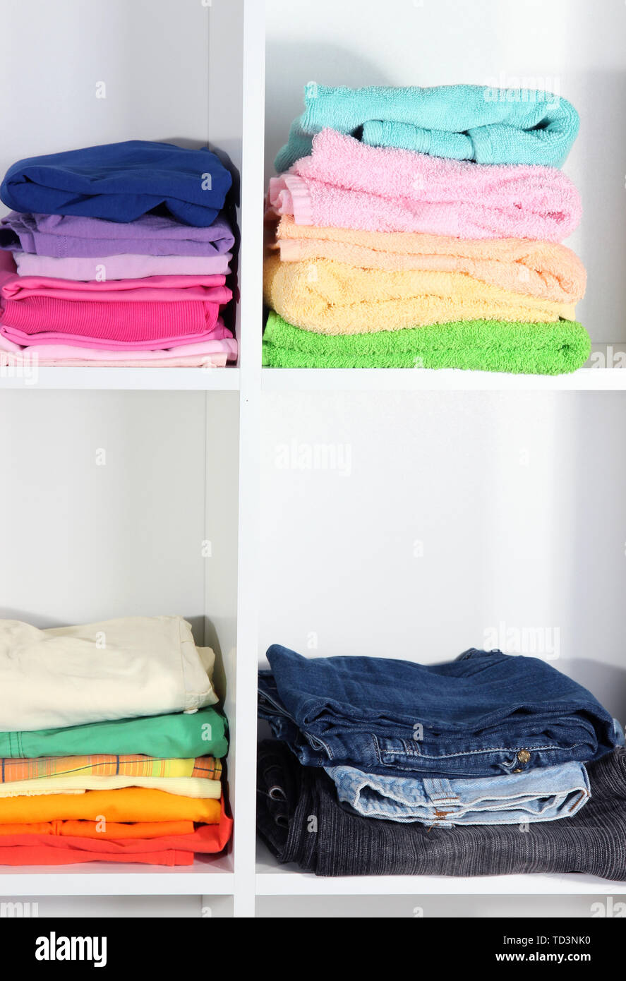 Clothes neatly folded on shelves Stock Photo - Alamy