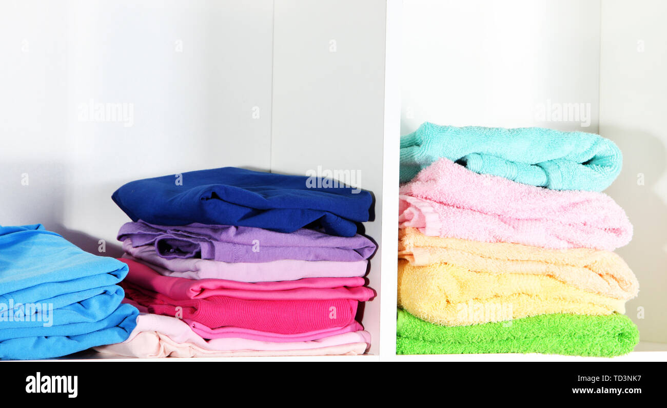 Clothes neatly folded on shelves Stock Photo - Alamy