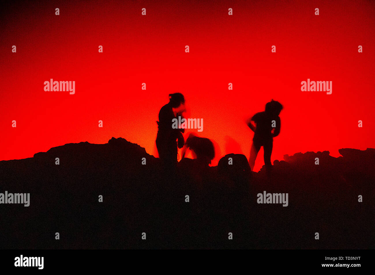 The night sky glows bright red as tourists explore the Erta Ale Volcano ...