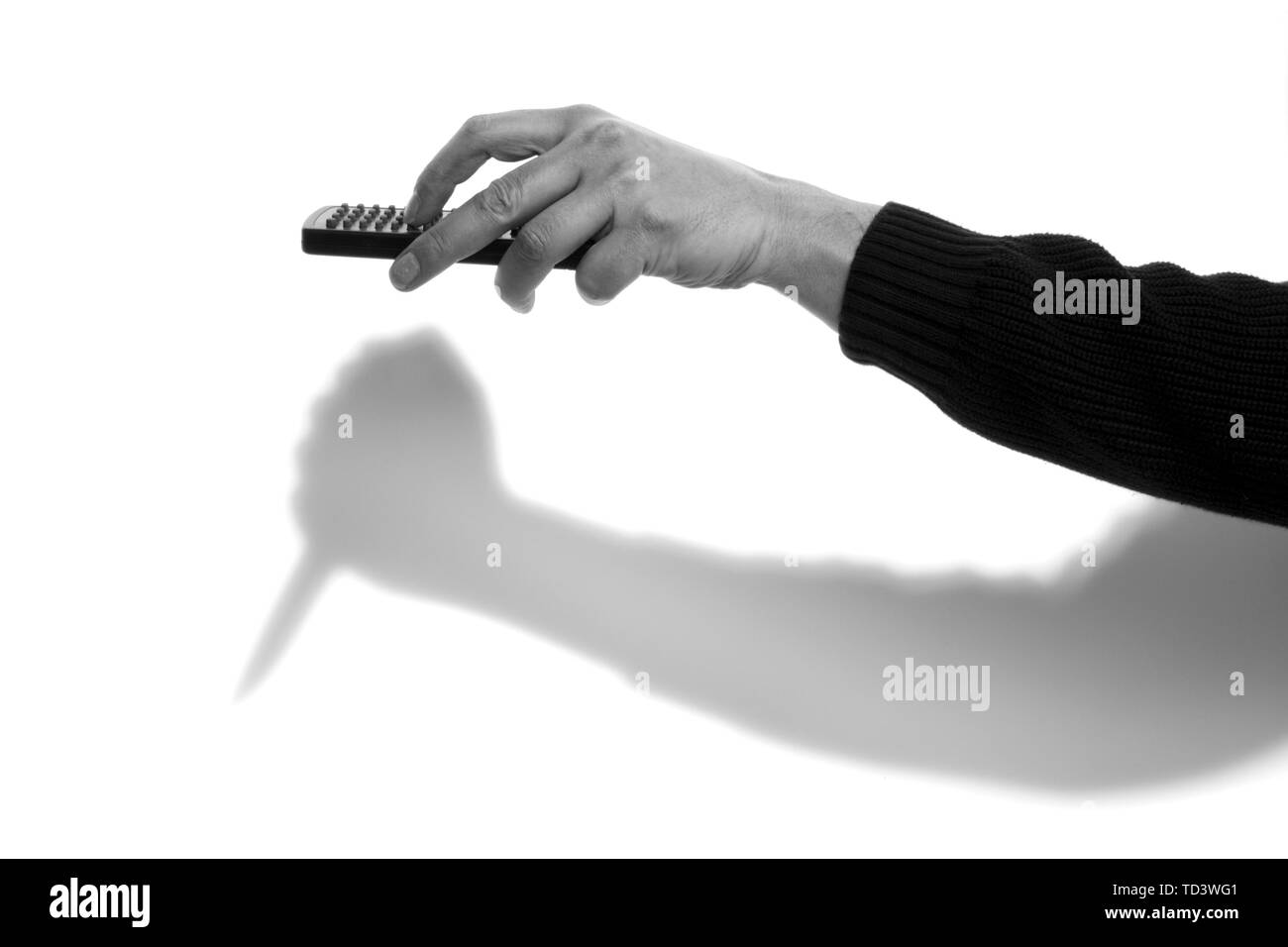 hand using remote control casting the shadow of a hand with a knife ...