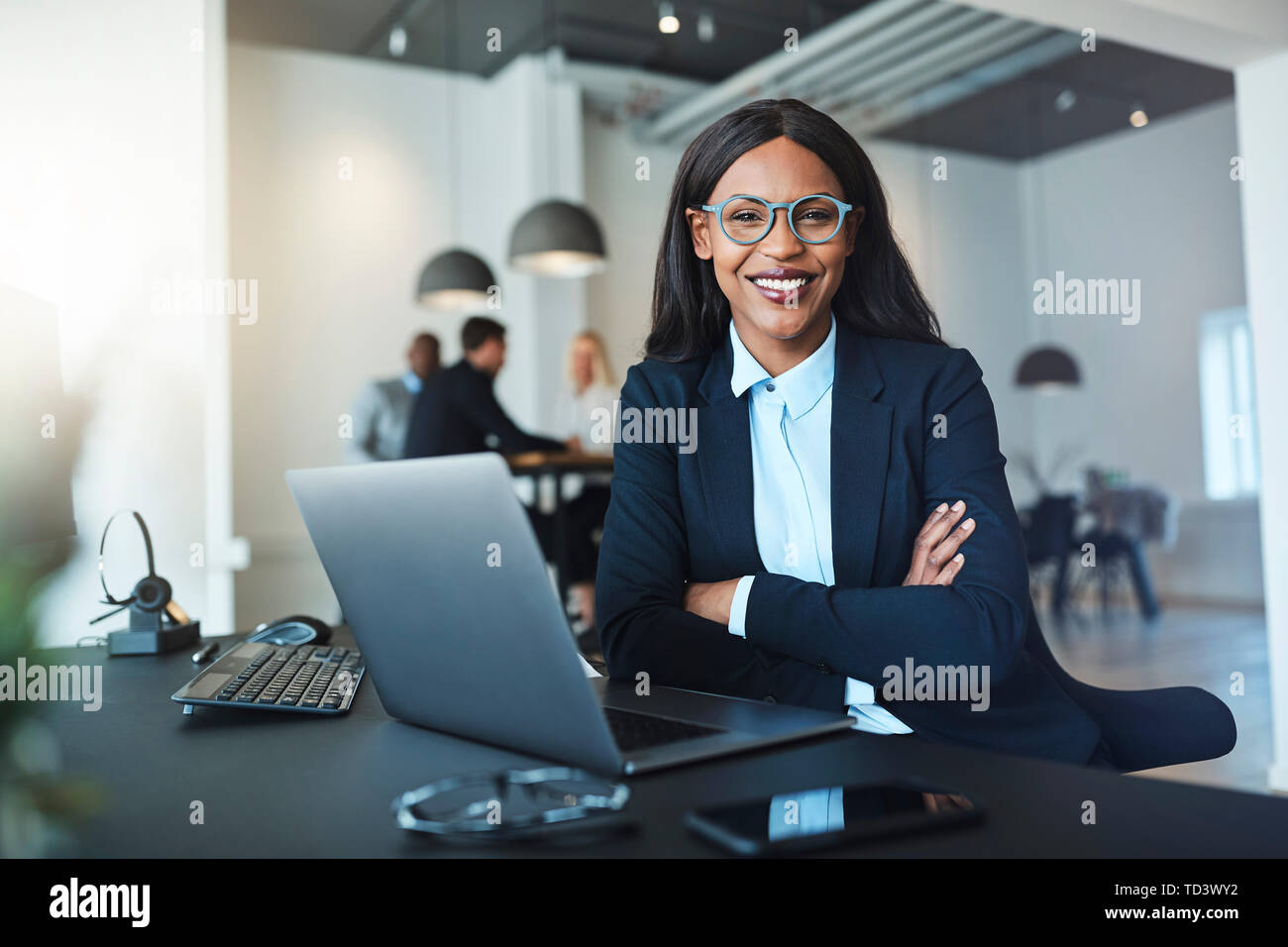 Confident young African American businesswoman smiling while sitting ...