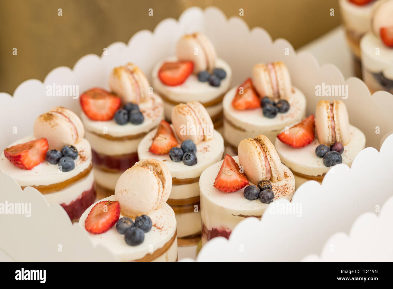 Various mini cakes. Sweets decorated with fresh berries for holiday ...