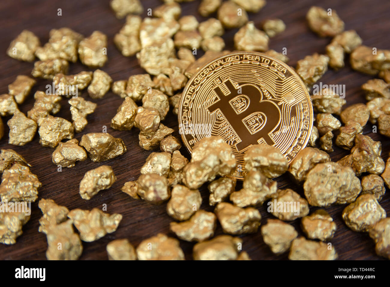 golden bitcoin on mound of gold nugget on dark wood background Stock ...