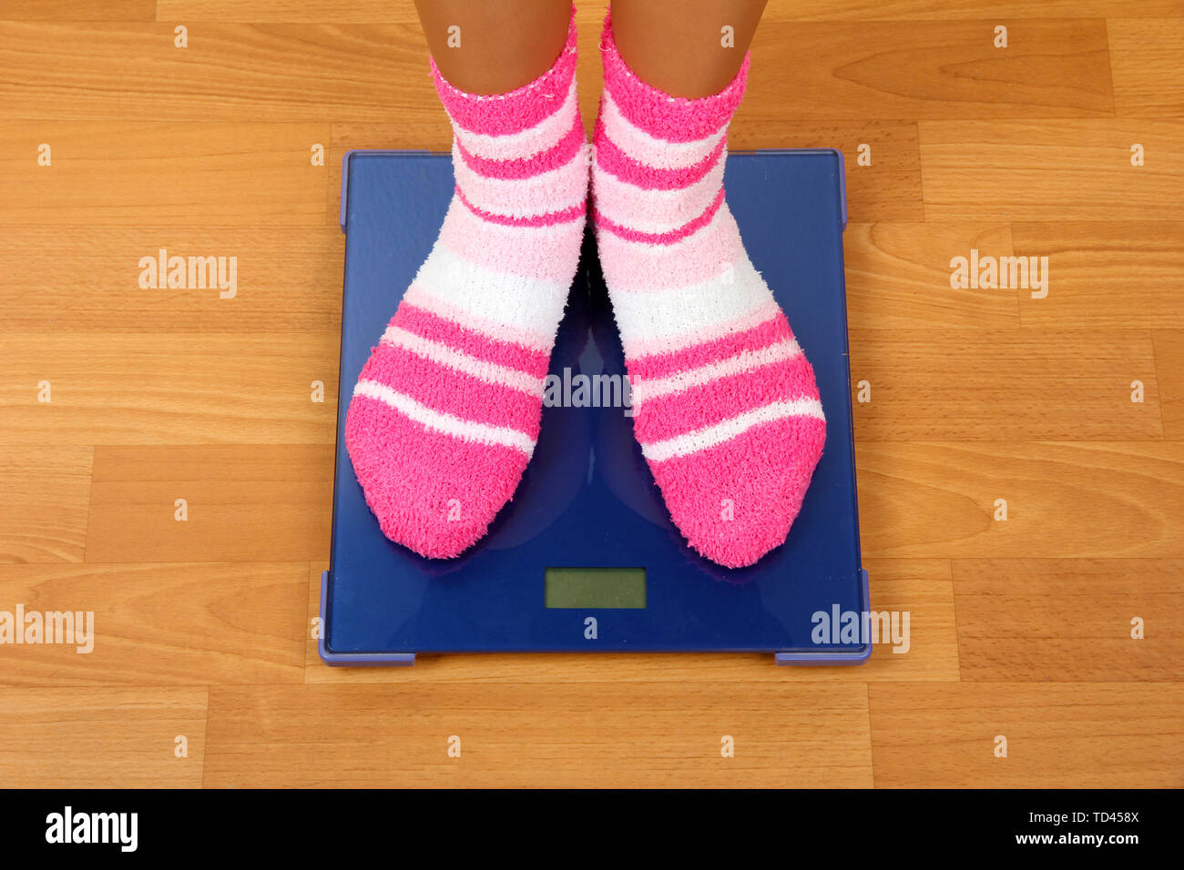 Feet on scales on floor in room Stock Photo - Alamy