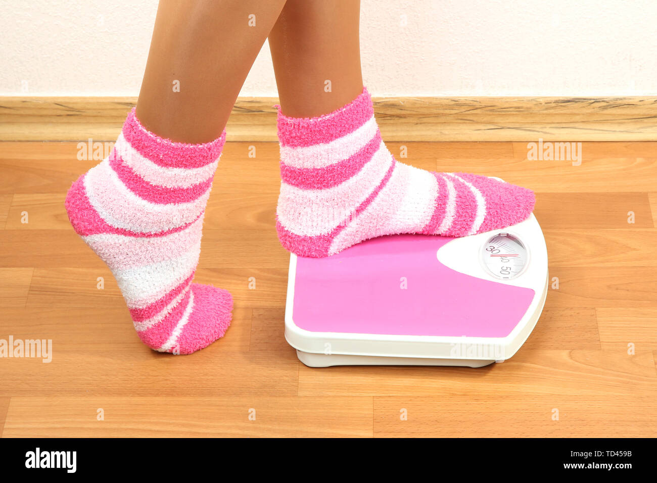 Feet on scales on floor in room Stock Photo - Alamy