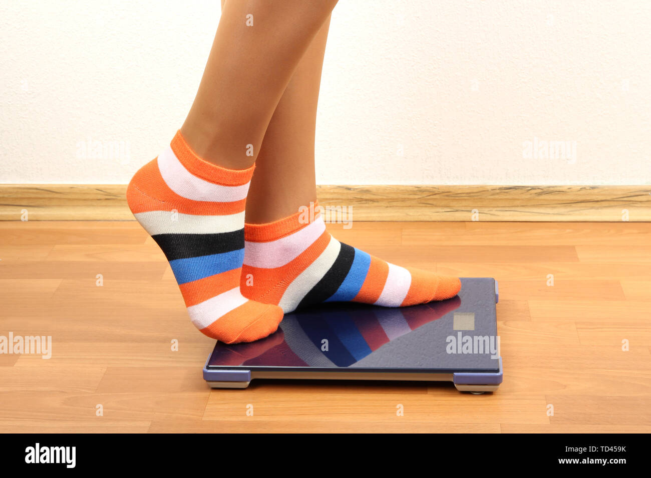 Feet on scales on floor in room Stock Photo - Alamy