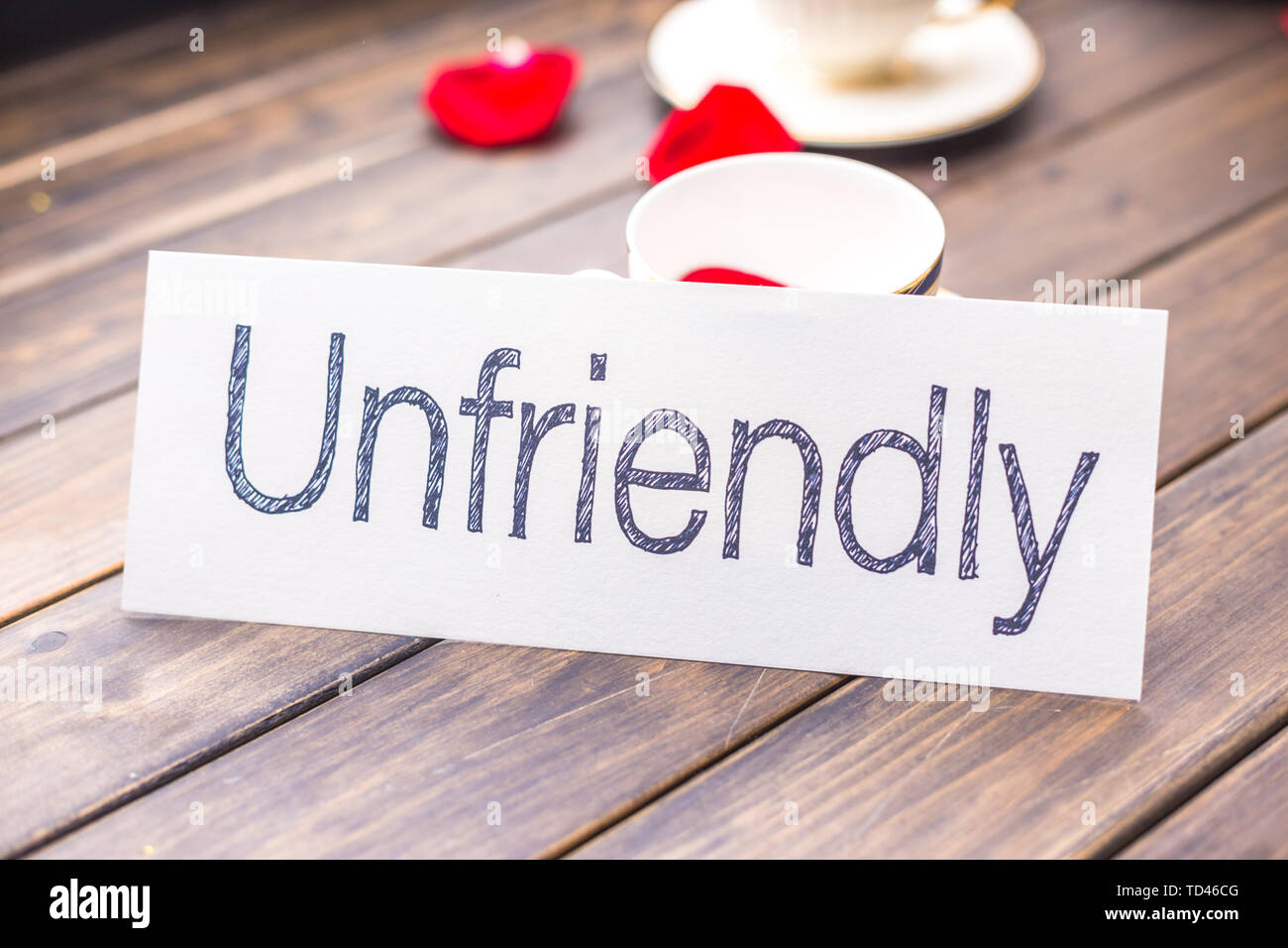 white paper with word unfriendly against elegant coffee cup in cafe ...