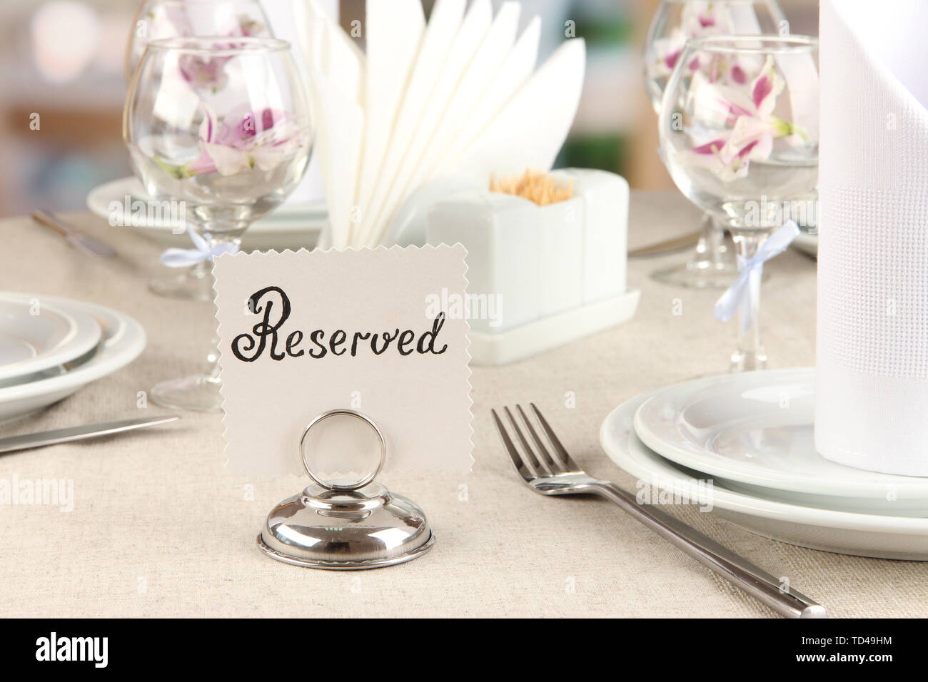 Reserved sign on restaurant table with empty dishes and glasses Stock ...